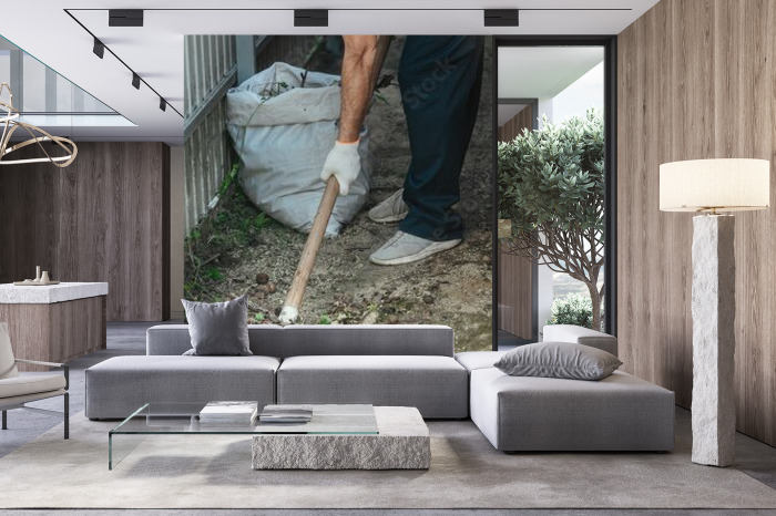 Fototapeta a man in his yard of the house puts things in order and ...